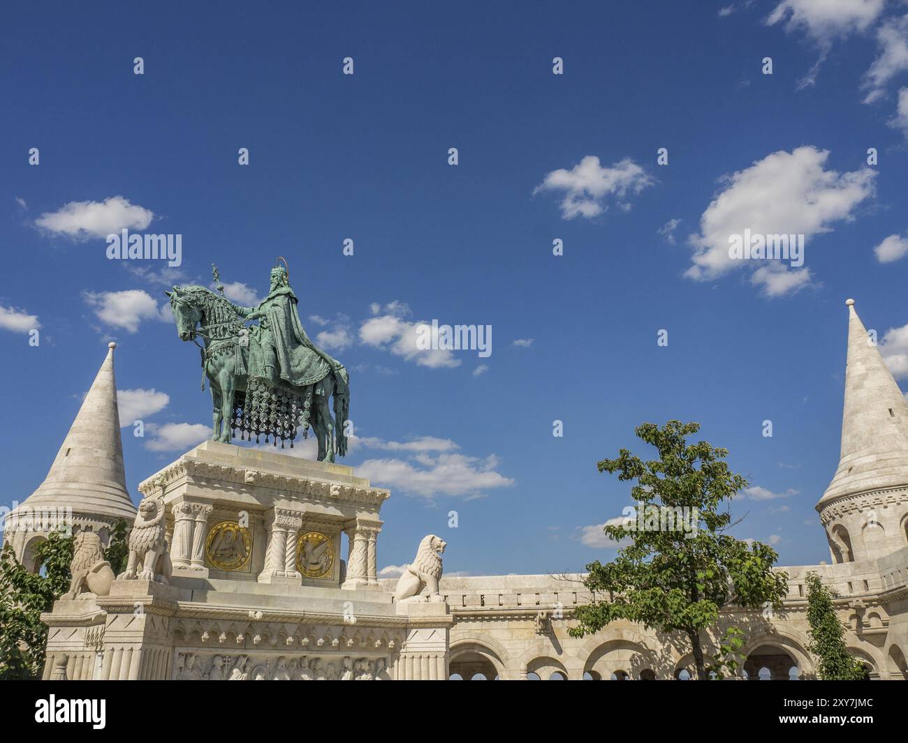 Equestrian statue and towers under a clear blue sky with white clouds ...