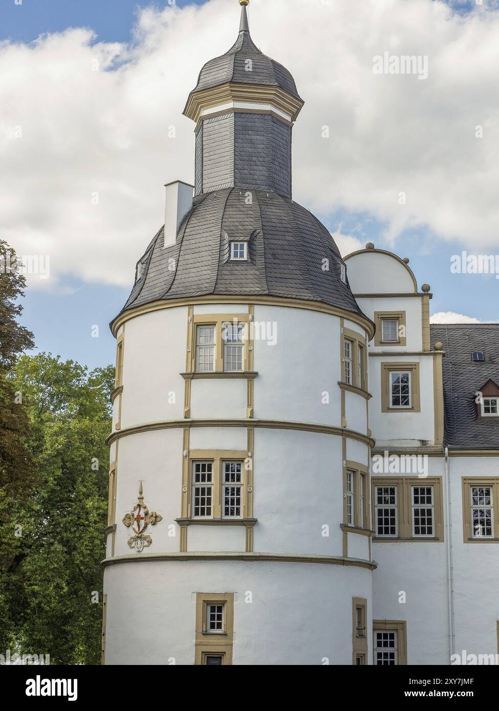 A historic castle tower with a white facade and grey roof under a ...