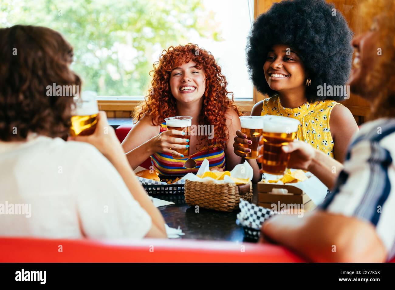 Multiethnic group of friends having meal at 80s vintage diner ...