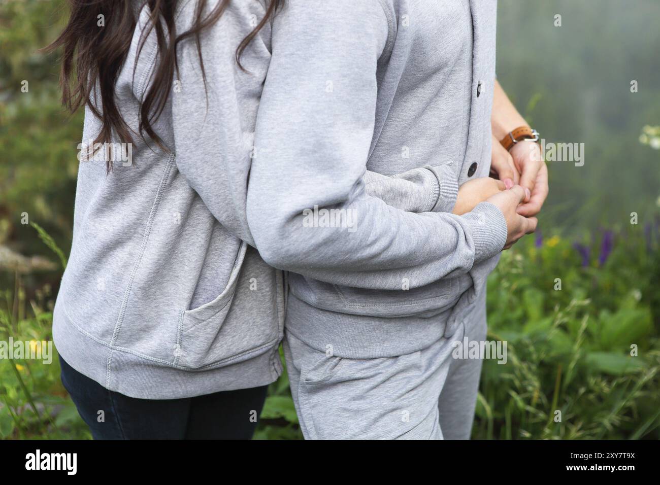 Young loving couple relaxing and hugging, she is smiling and leaning on ...