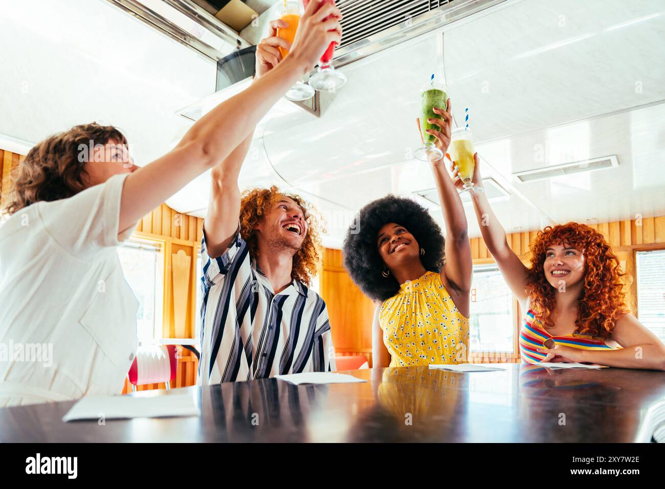 Multiethnic group of friends meeting and drinking milkshakes cocktails ...