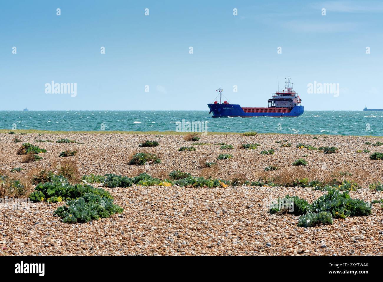 A small cargo boat entering Shoreham harbour on a sunny summers day ...