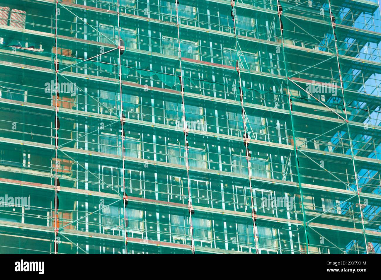 Close-up of a construction site with scaffolding and green safety ...