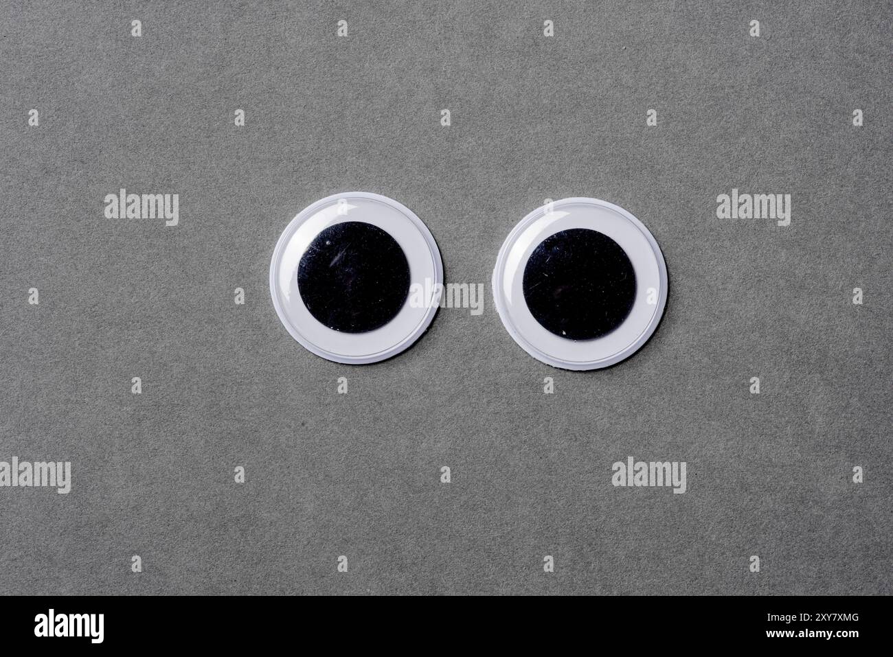 Googly eyes on grey background looking straight forward Stock Photo - Alamy