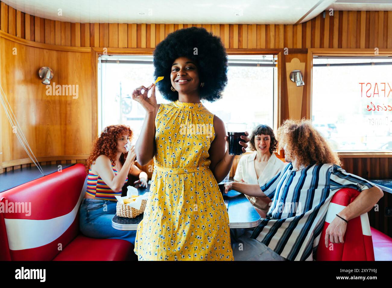 Multiethnic group of friends having meal at 80s vintage diner ...