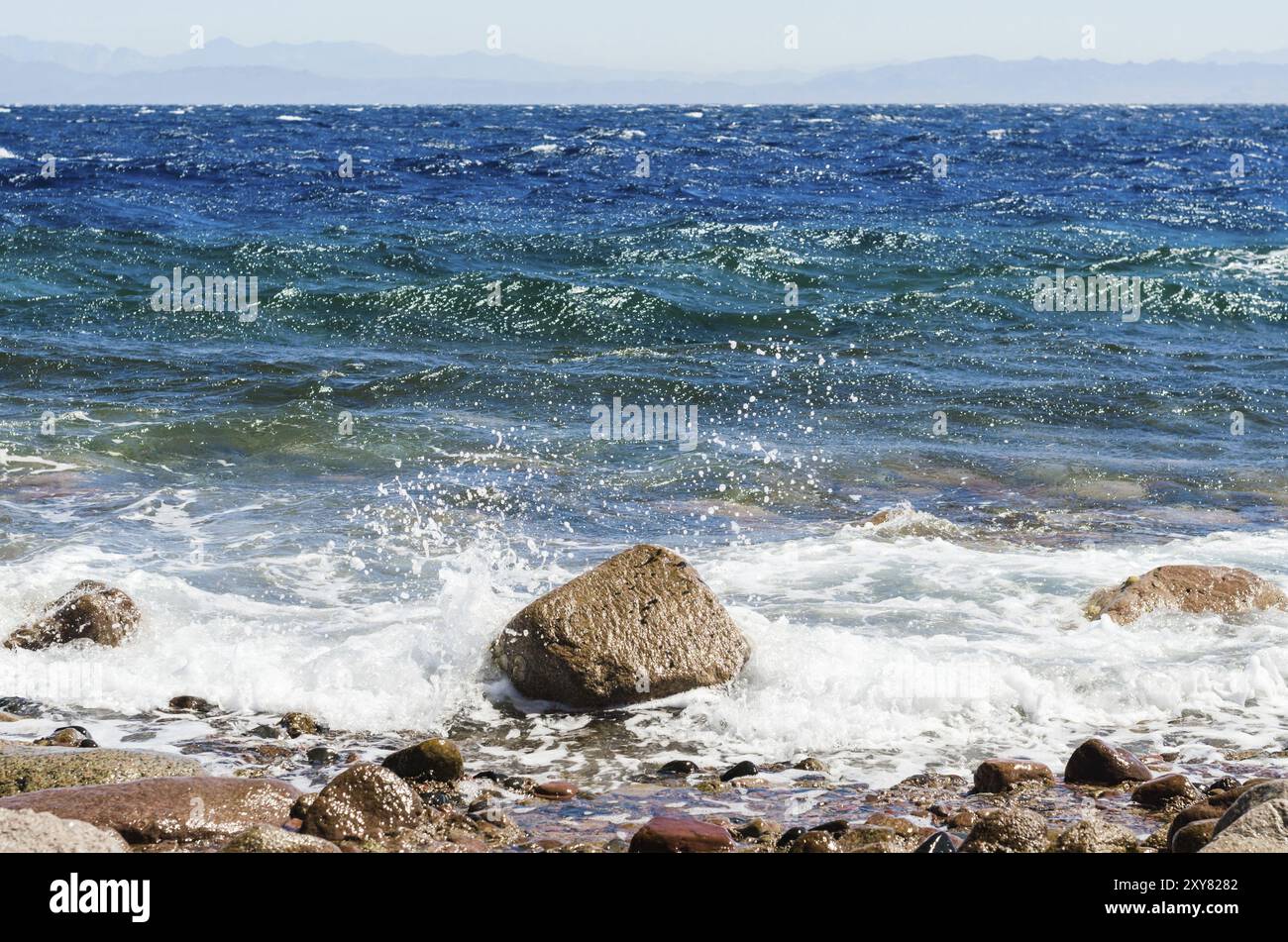 Waves and splashes of sea surf and stones on the seashore Stock Photo ...