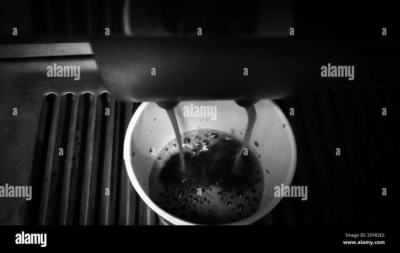 Close-up of Americano pouring from the coffee machine into a cup ...