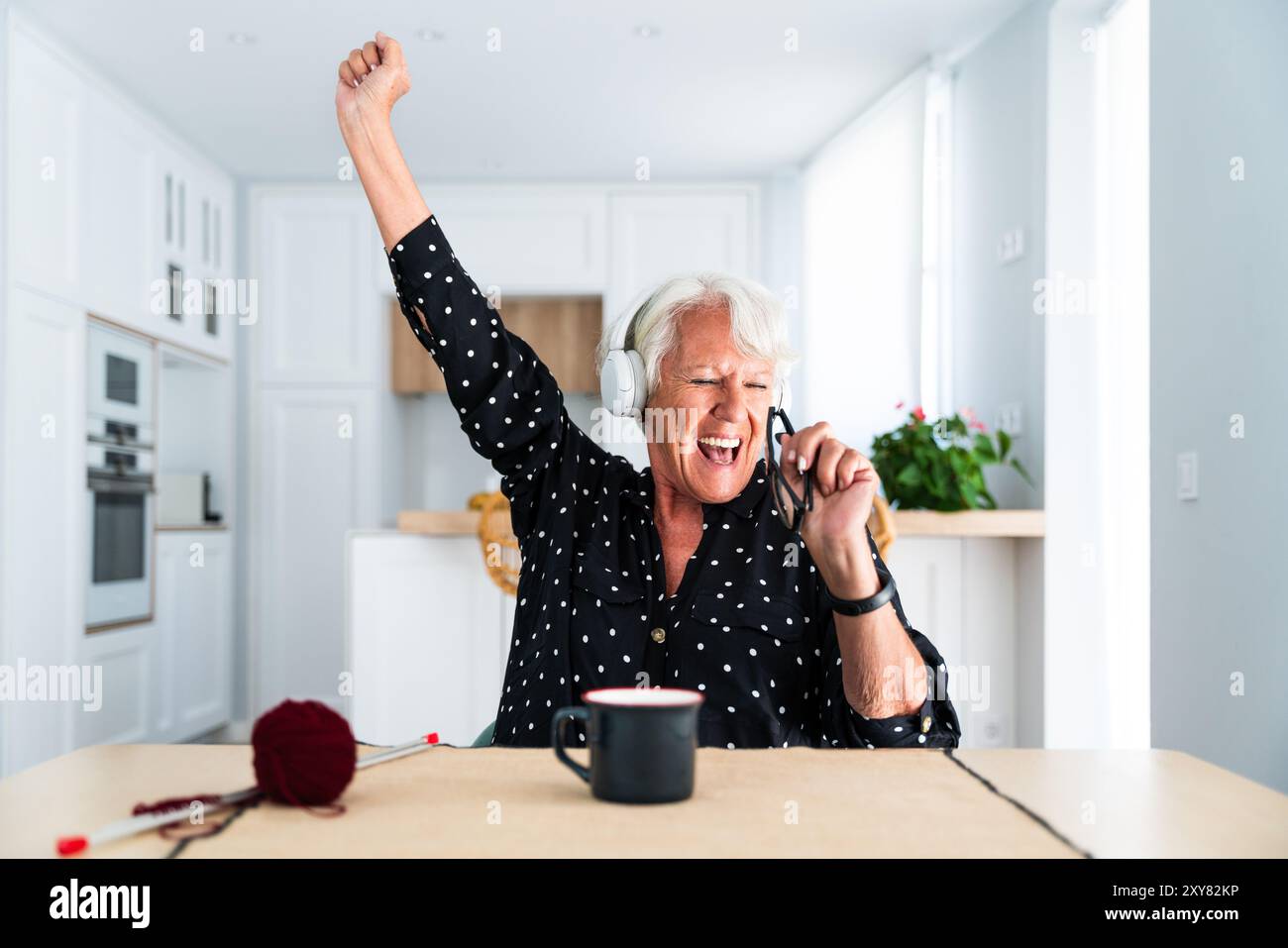 Beautiful senior old woman with gray hair at home singing while ...