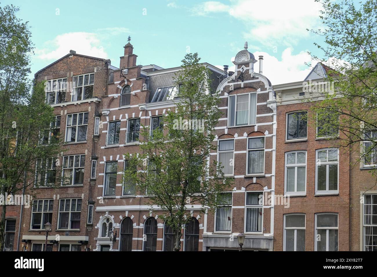 Historic buildings with striking facades and trees in front, Amsterdam ...