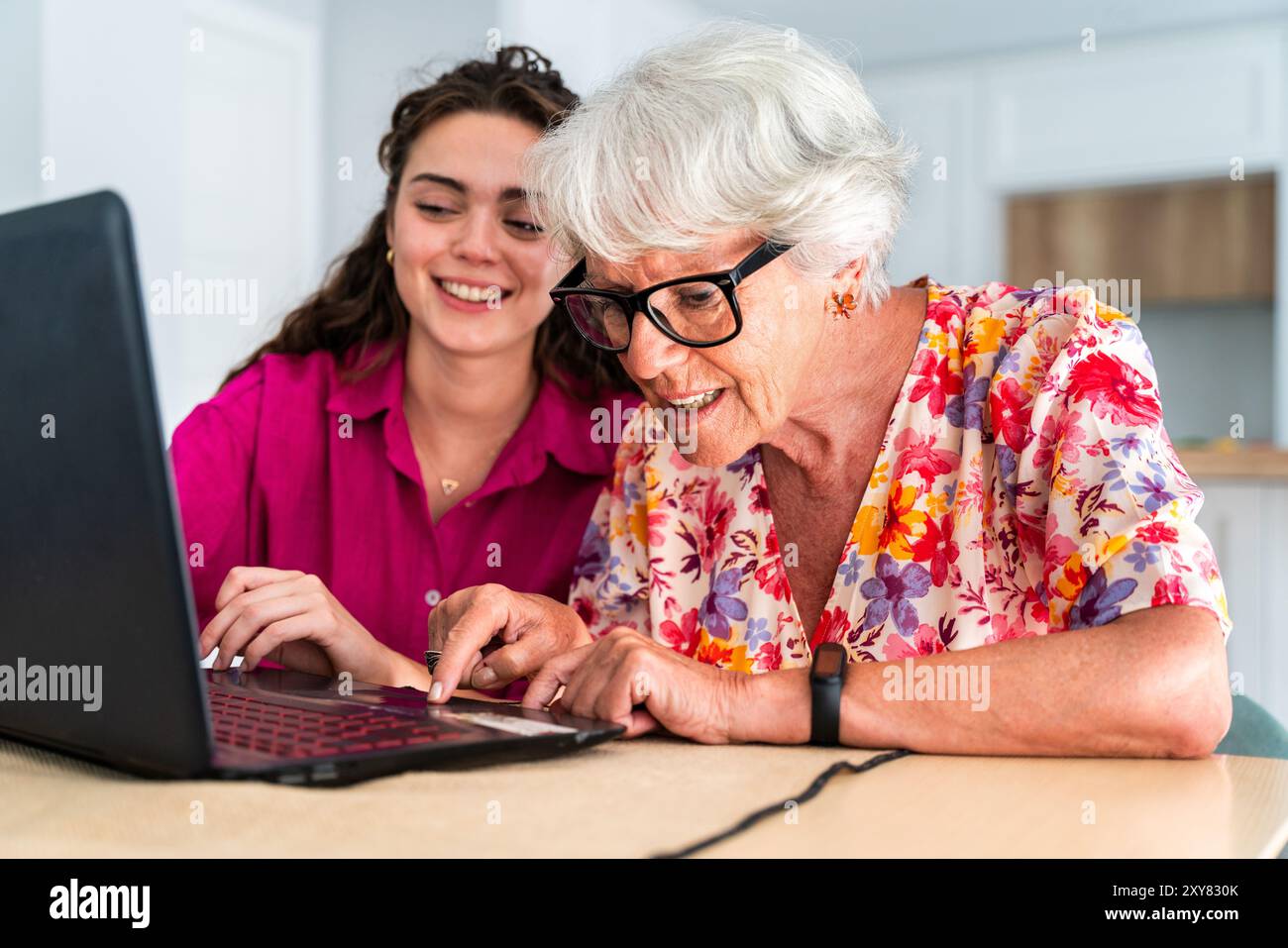 Beautiful grandmother and granddaughter together at home teaching how ...