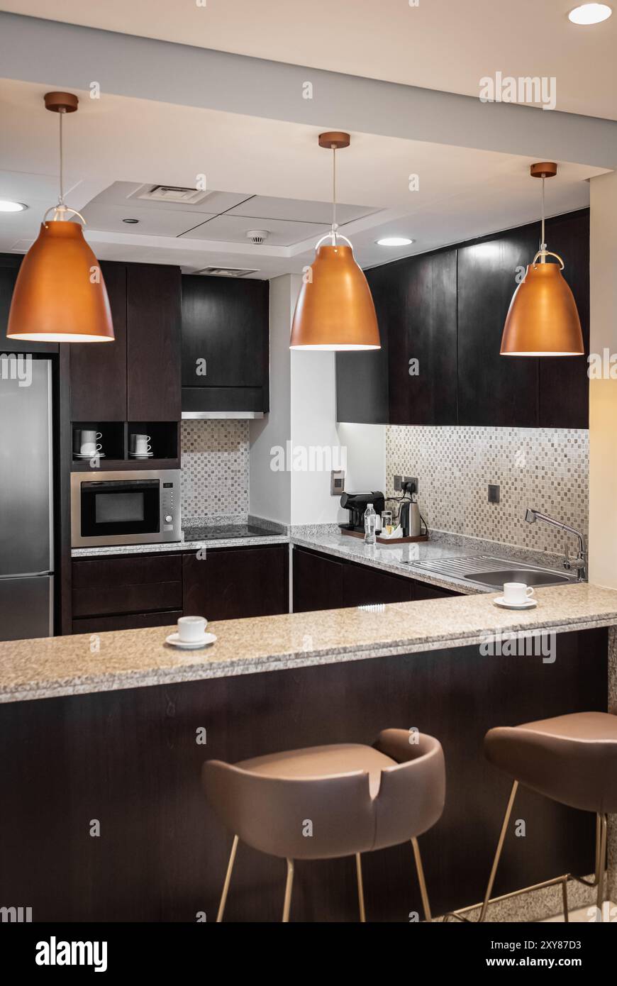 A modern kitchen with cabinets and a marble island, stainless steel ...