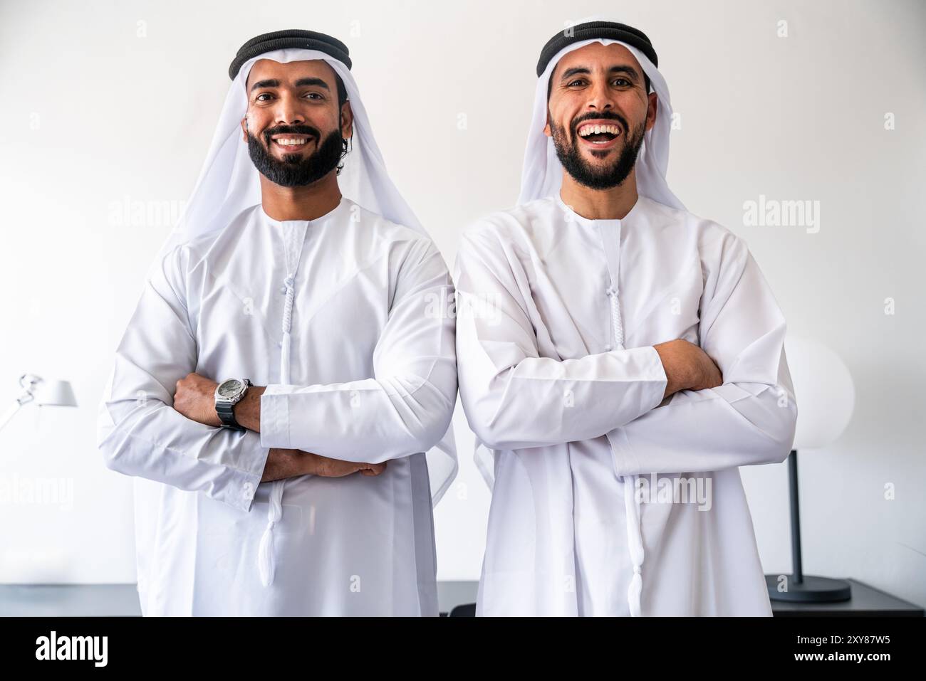 Arab men wearing traditional emirate clothing working in the office ...