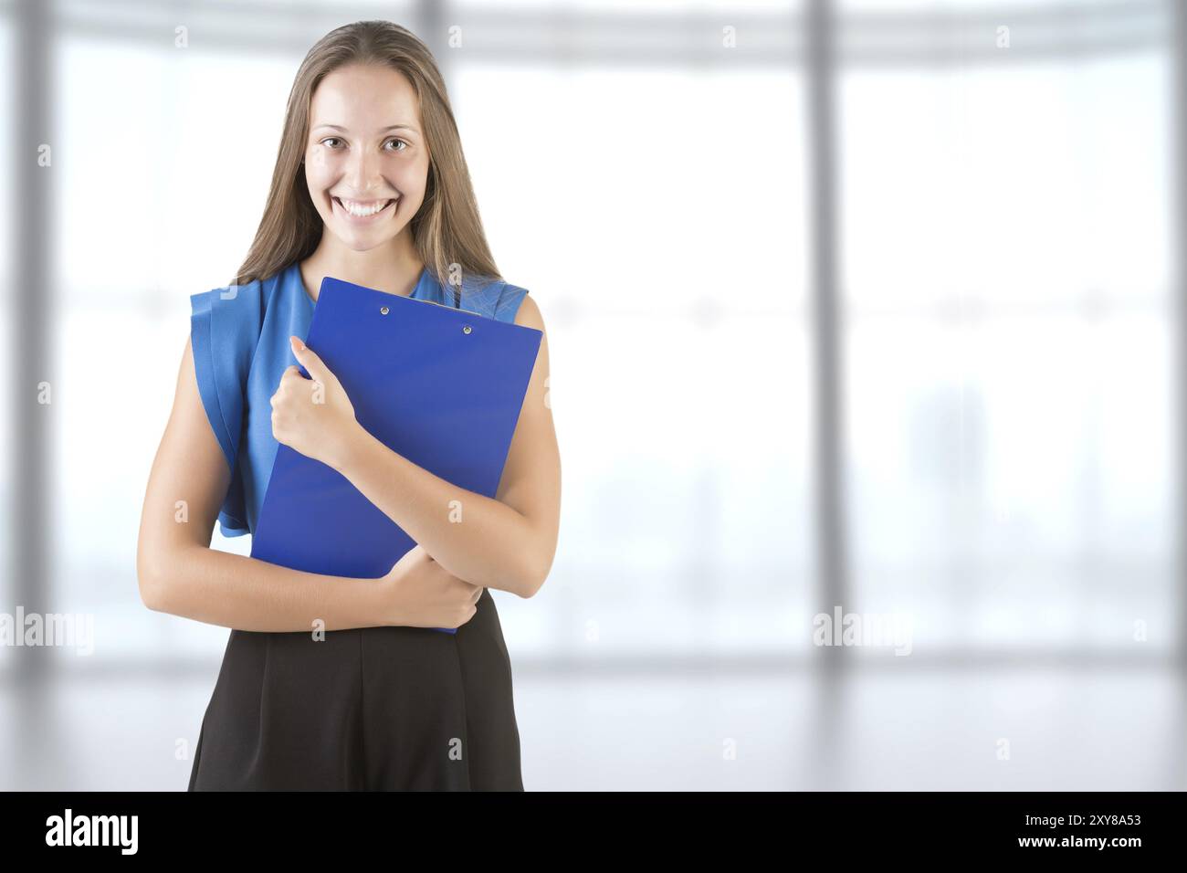 Young woman carrying notebooks in her arms, in a school Stock Photo - Alamy