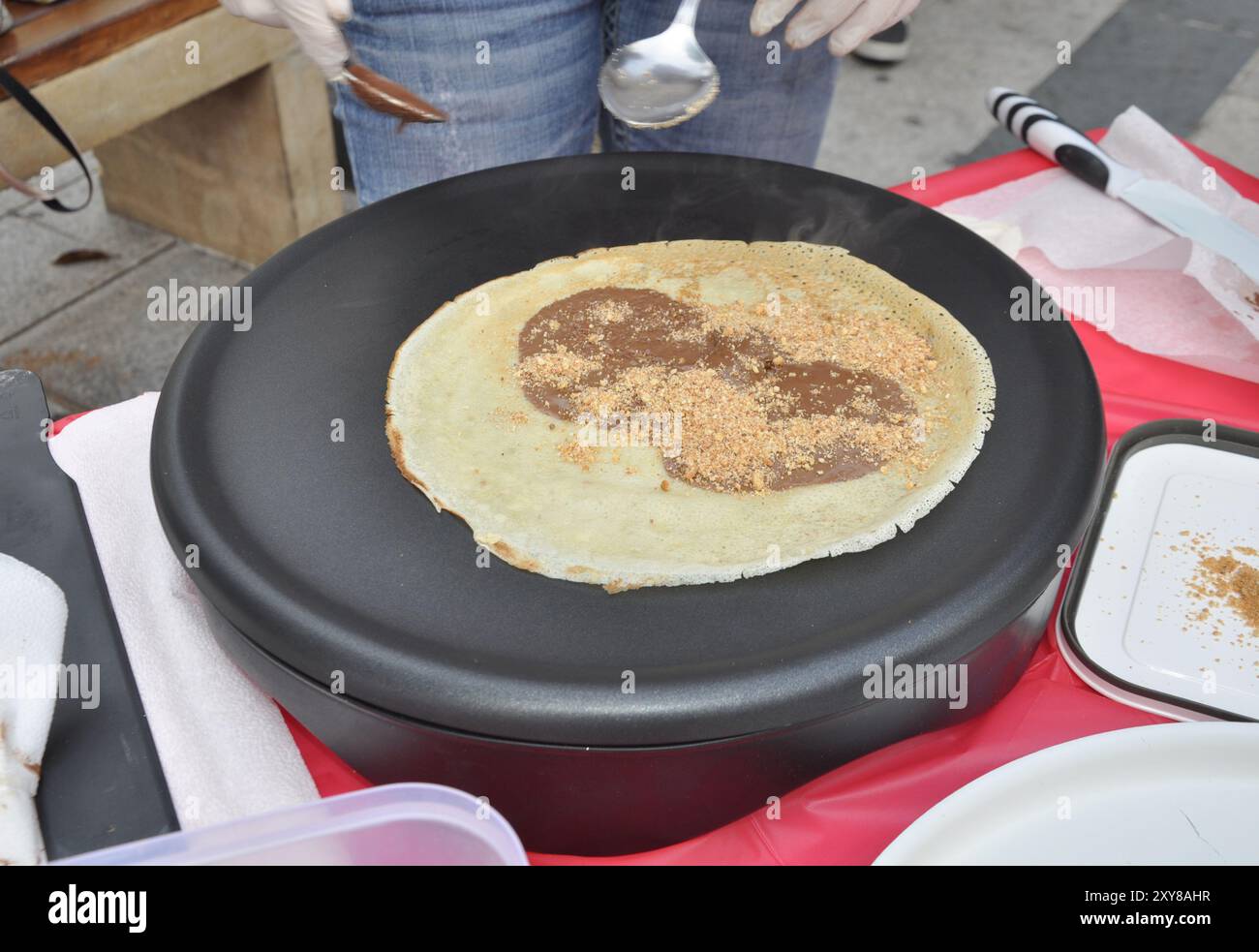The cooking crepes chocolate and cookies with a crepe maker Stock Photo ...