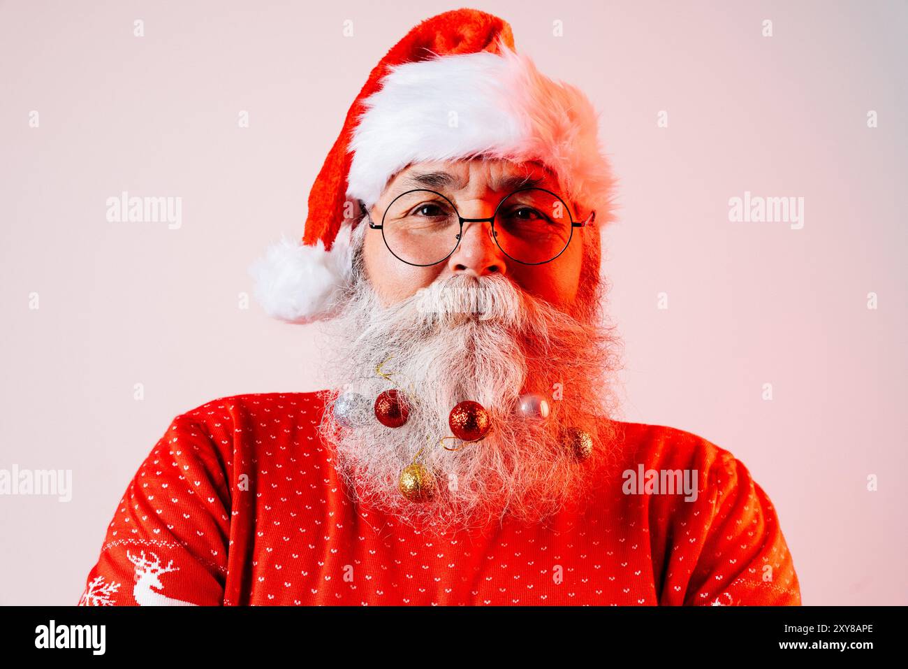 Senior old man with gray beard with Santa Claus portrait in studio ...
