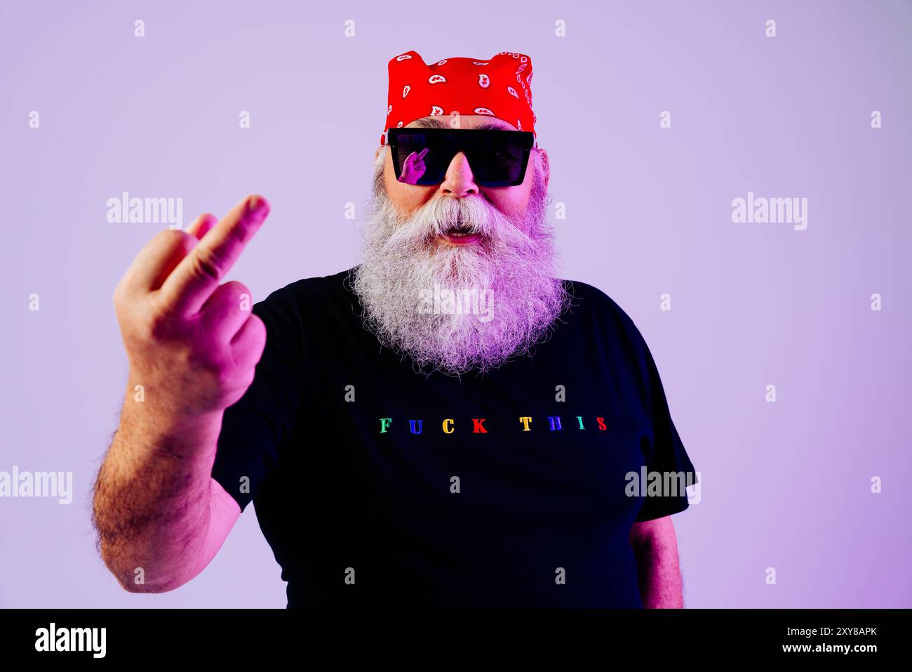 Senior old man with gray beard doing rude rebel gesture, portrait in ...