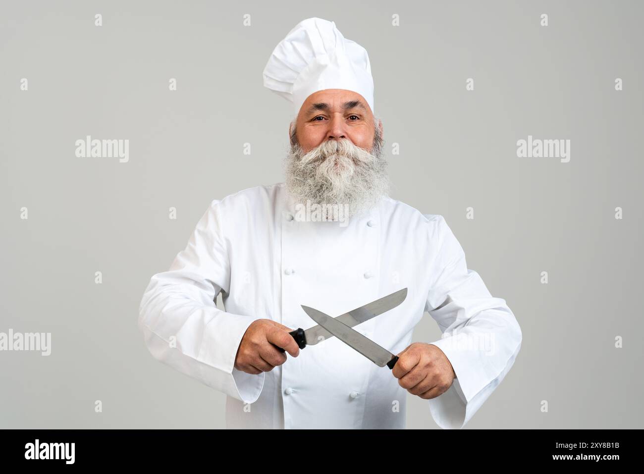 Senior old man with cooking chef uniform and gray beard portrait in ...