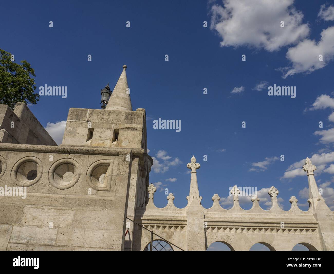 Historic stone wall with decorative tower and ornaments under a blue ...