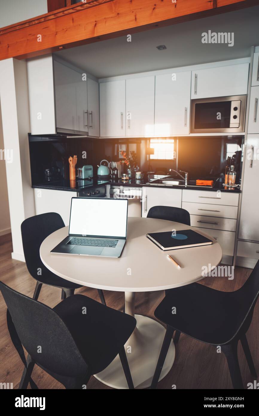 A modern kitchen interior with white cabinets, black countertops, and ...