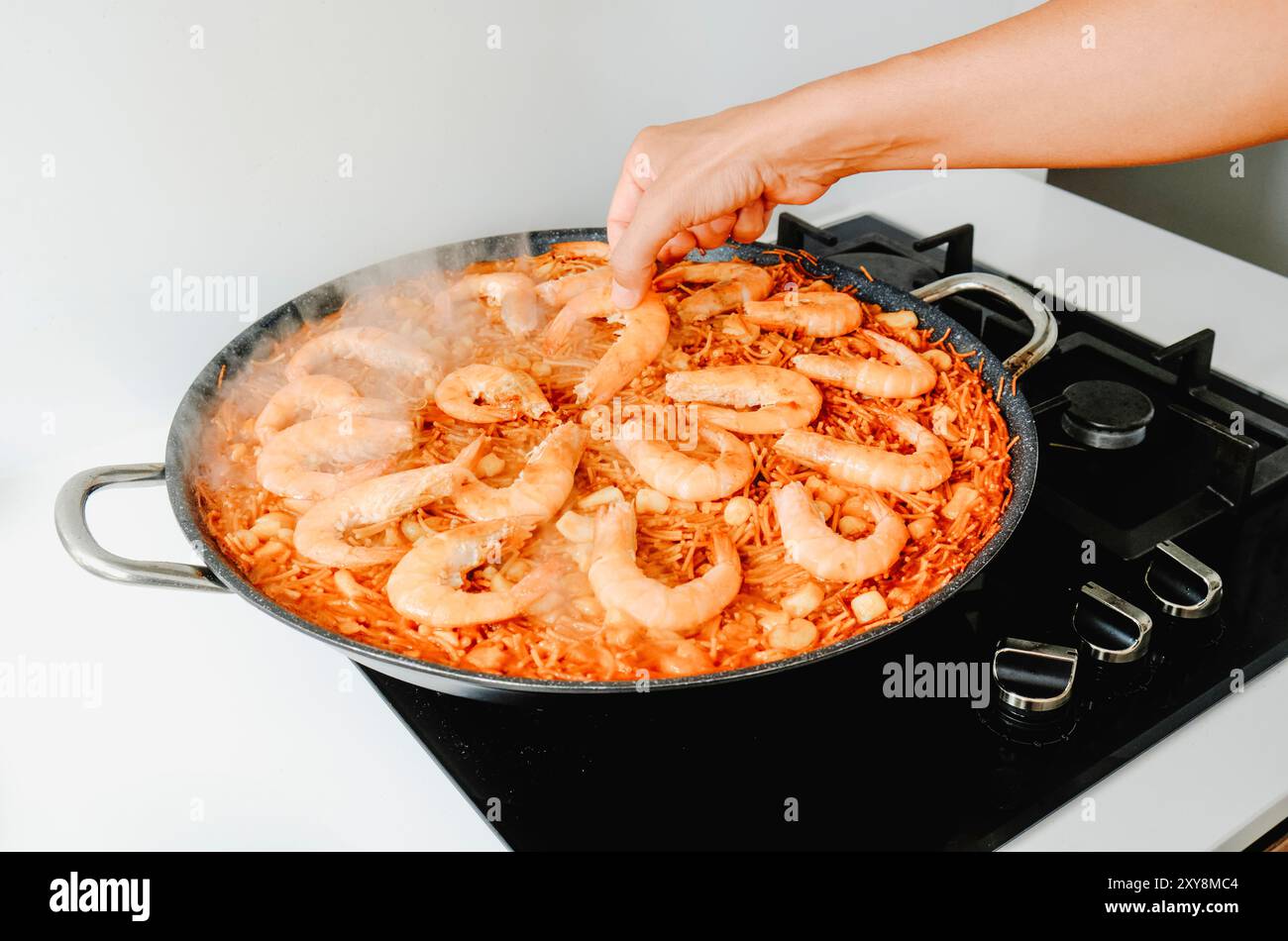 Cooking spanish paella adding seafood hi-res stock photography and ...