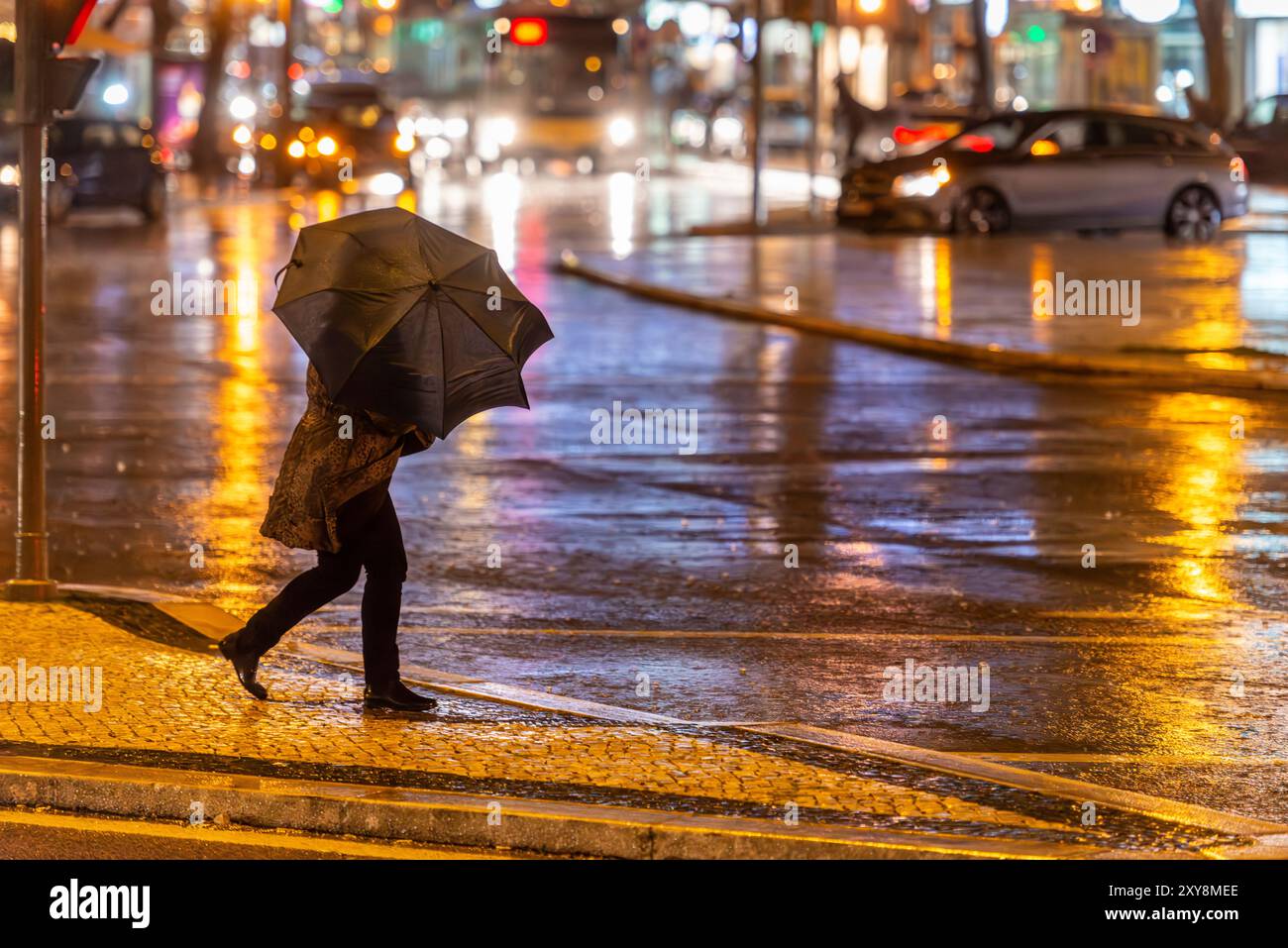 Woman crossing the street in an urban center, holding a colorful ...