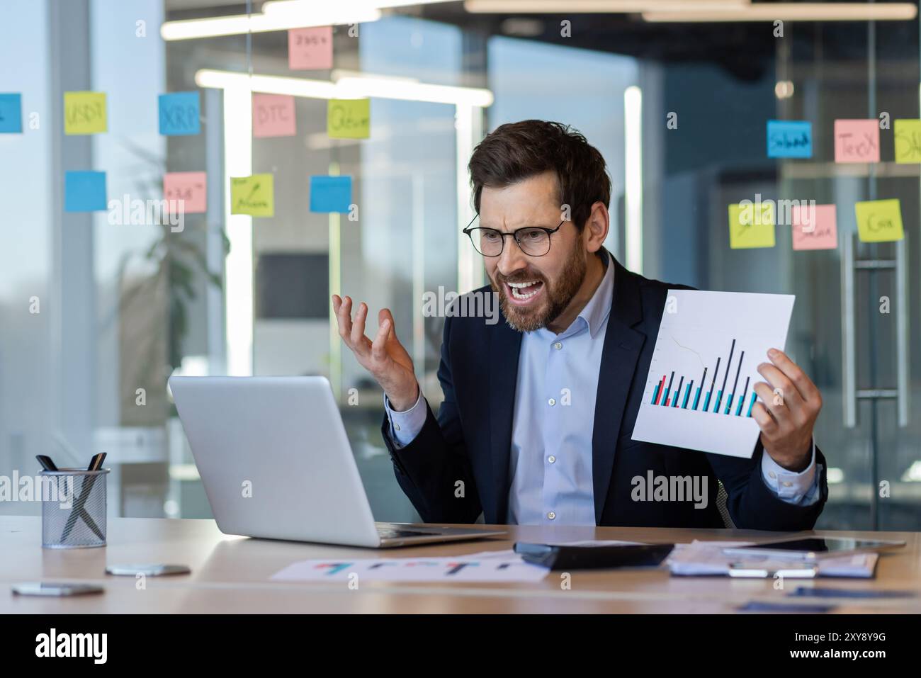 Businessman in modern office showing anger during video call. Holding ...