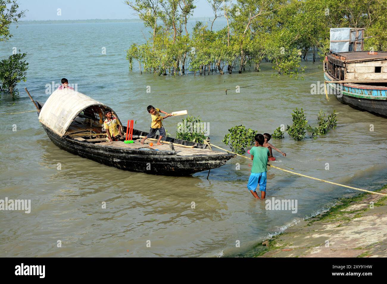 The remote village children are playing a cricket in the little boat ...