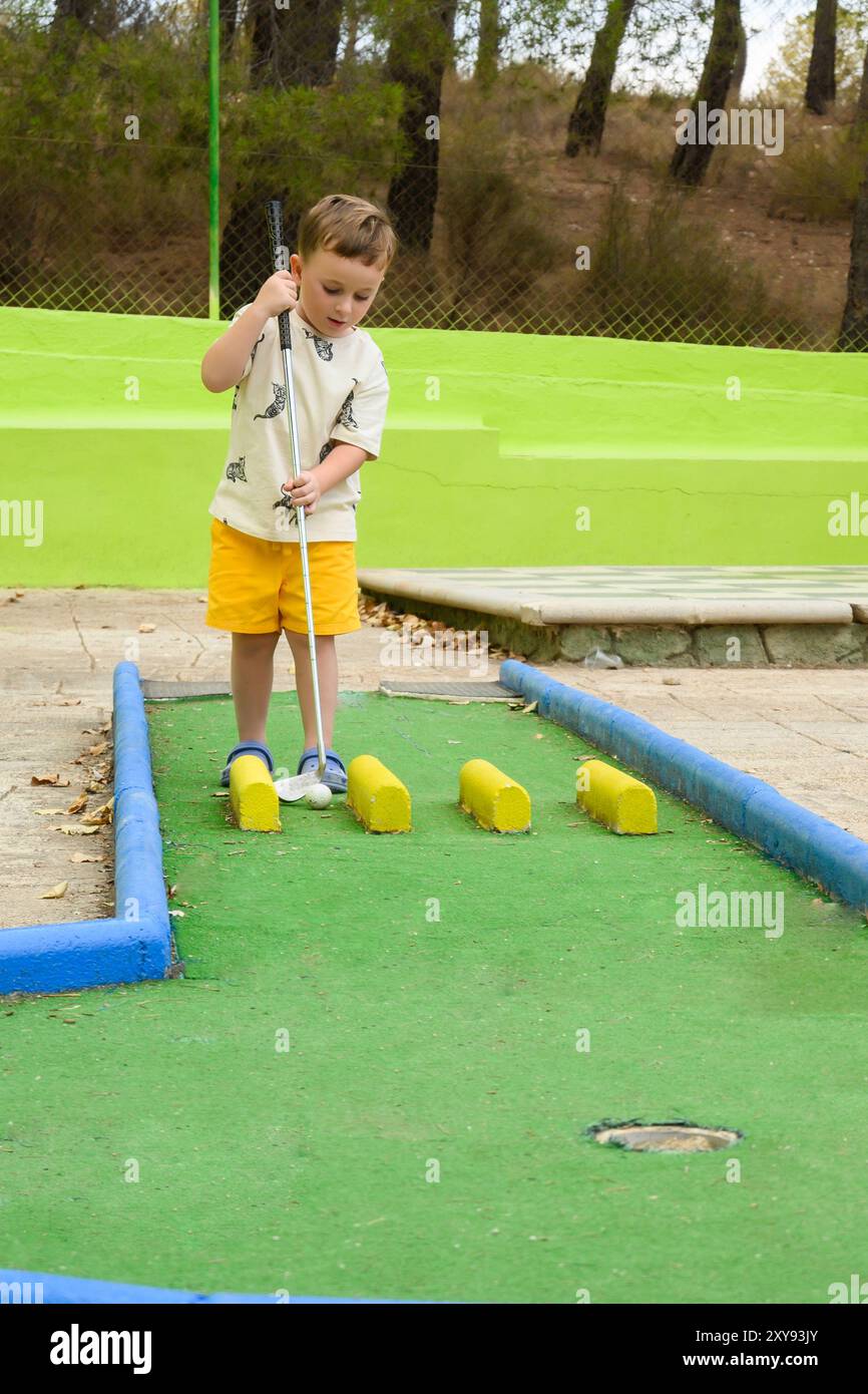 Kids playing mini golf on summer evening on the territory of the hotel ...