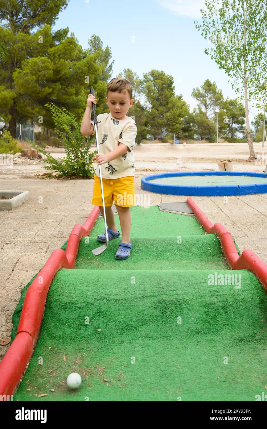 Kids playing mini golf on summer evening on the territory of the hotel ...