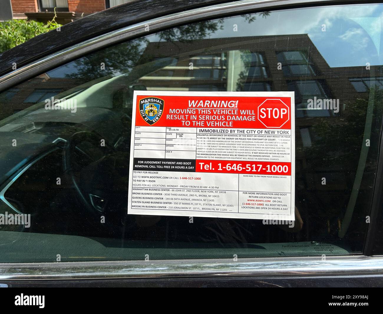 Wheel clamp device warning sign on car window Stock Photo - Alamy