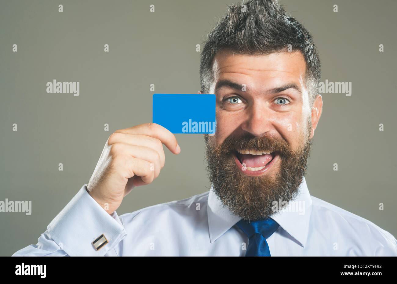 Smiling corporate man showing his debit card Stock Photo - Alamy