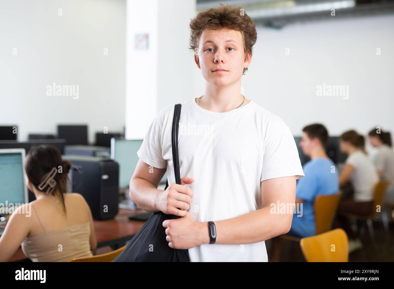 Teenager boy standing in computer class Stock Photo - Alamy