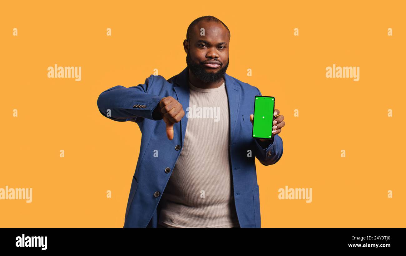 Upset african american man showing thumbs down sign gesturing holding ...
