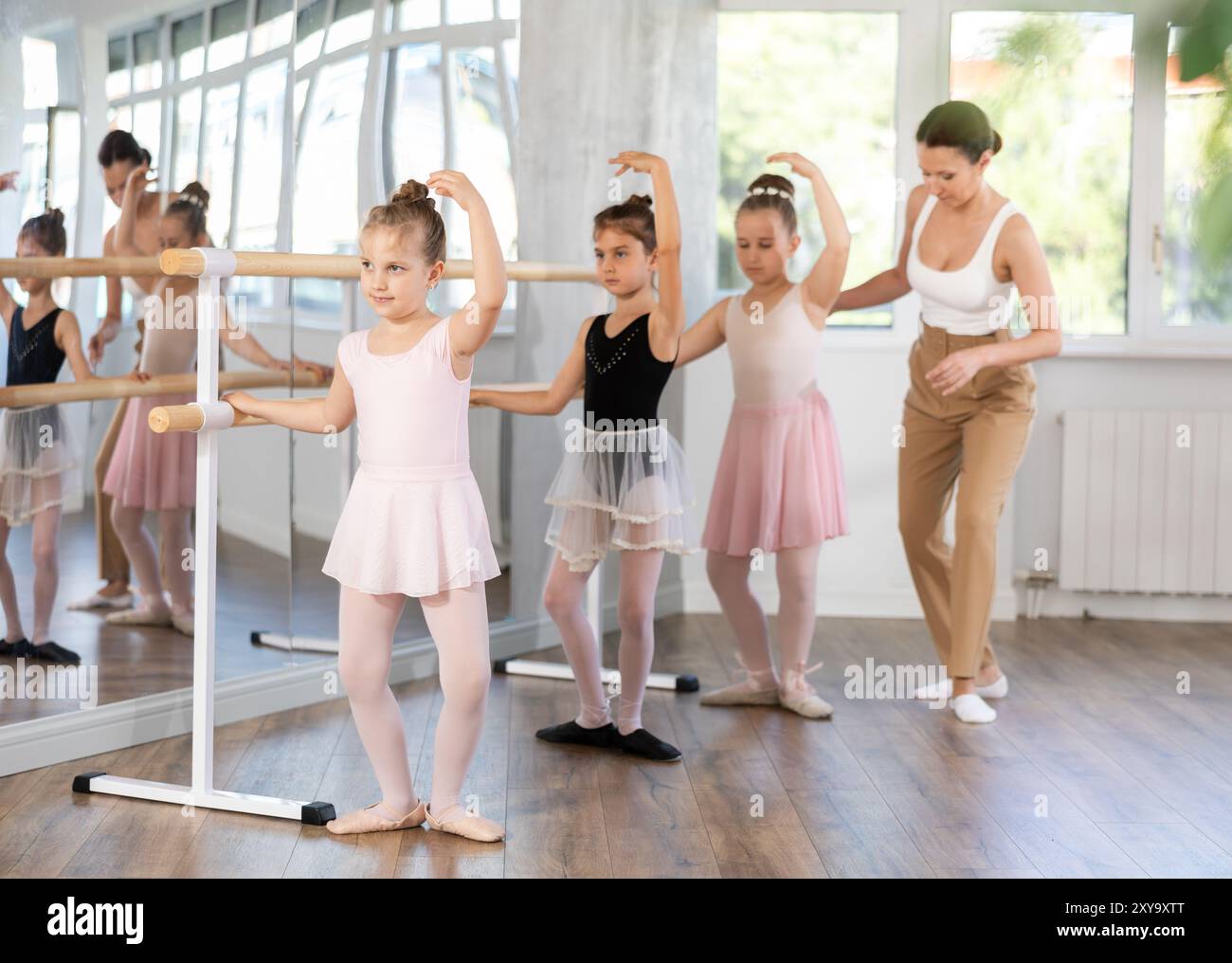 Woman teacher corrects girls in plie movement Stock Photo - Alamy