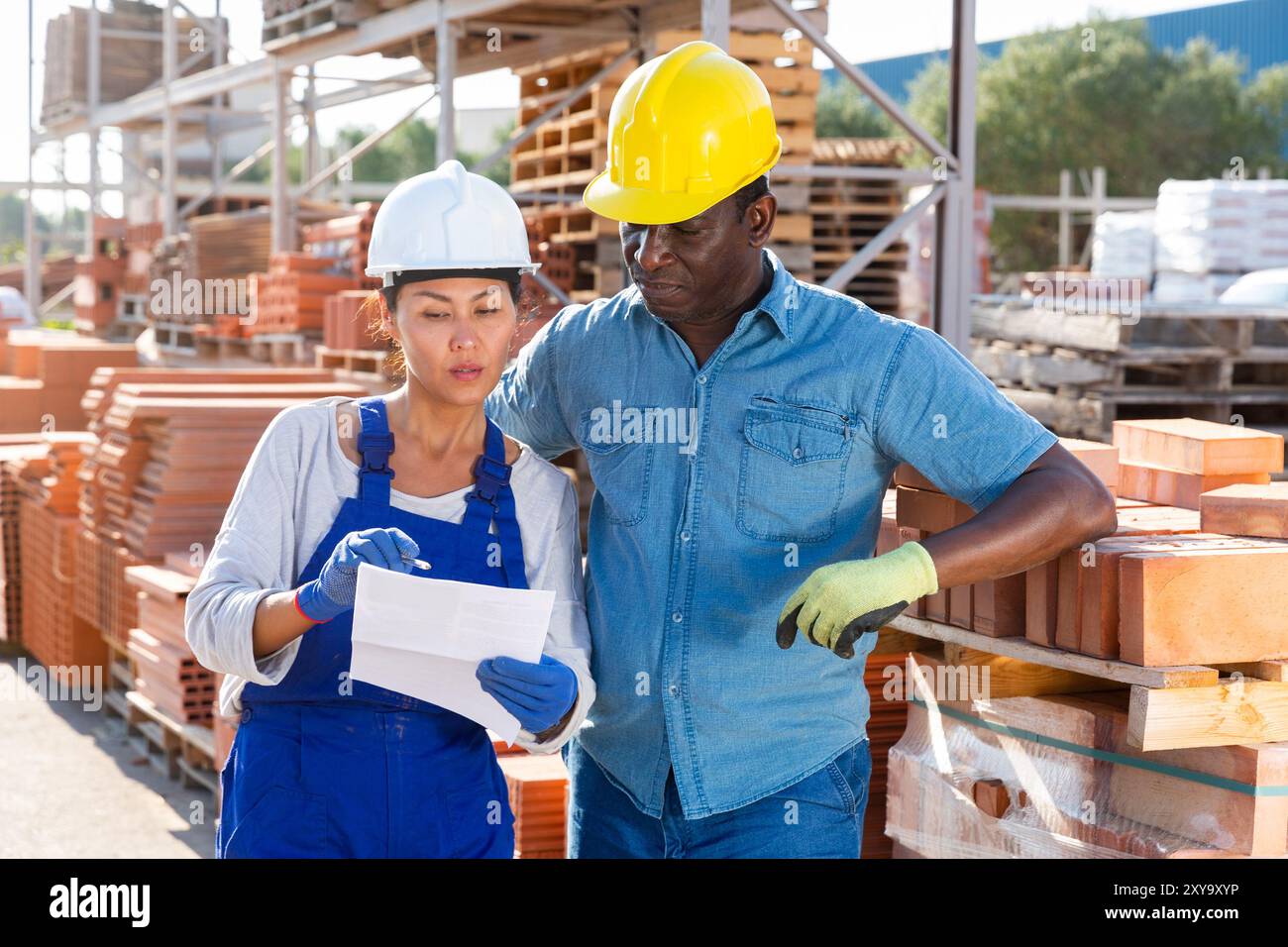 Builders talking about documentation in storage Stock Photo - Alamy