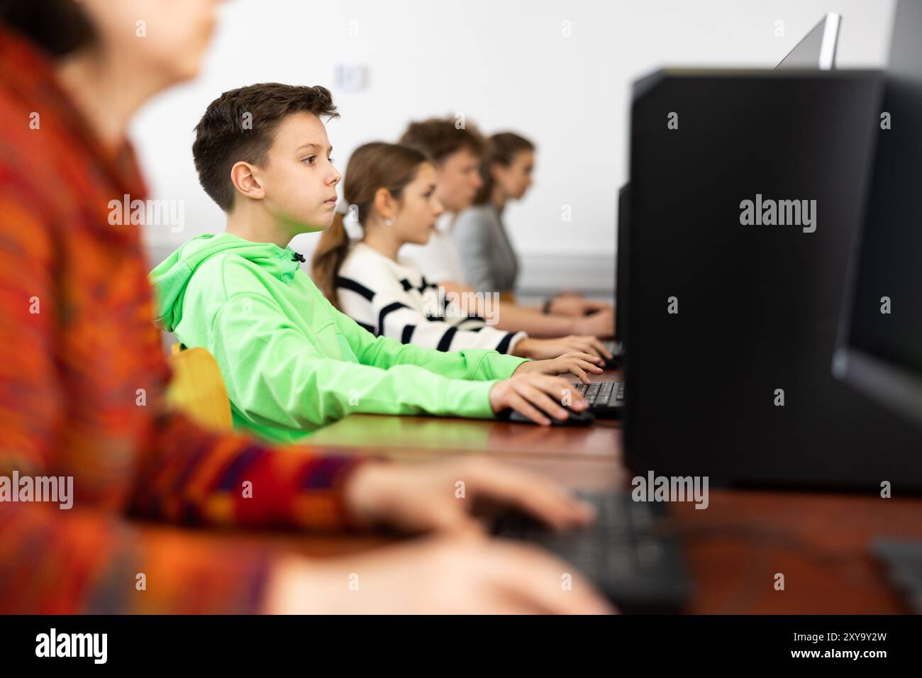 Young boy using computer during lesson Stock Photo - Alamy