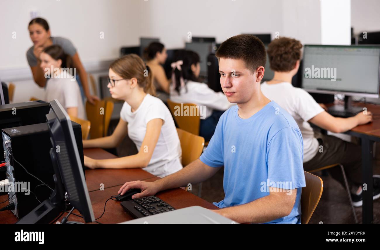 Teenage boy using computer during lesson Stock Photo - Alamy