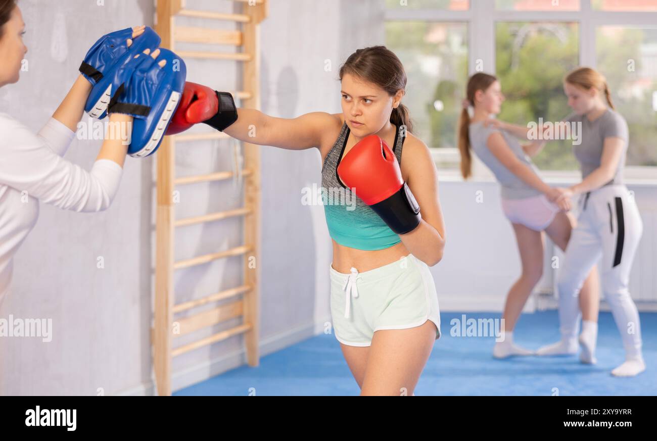 Boxing training - teen girl wearing boxing gloves exercise and punch to ...