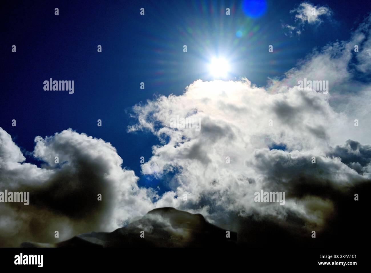 Deep dark blue sky with brilliant starry sun shining through ragged ...