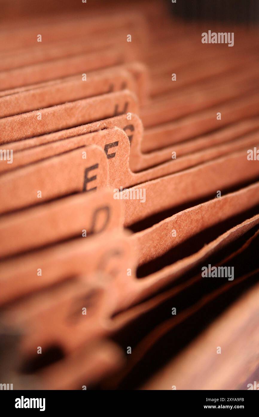 Close-up of brown file folders with tabs labeled alphabetically ...