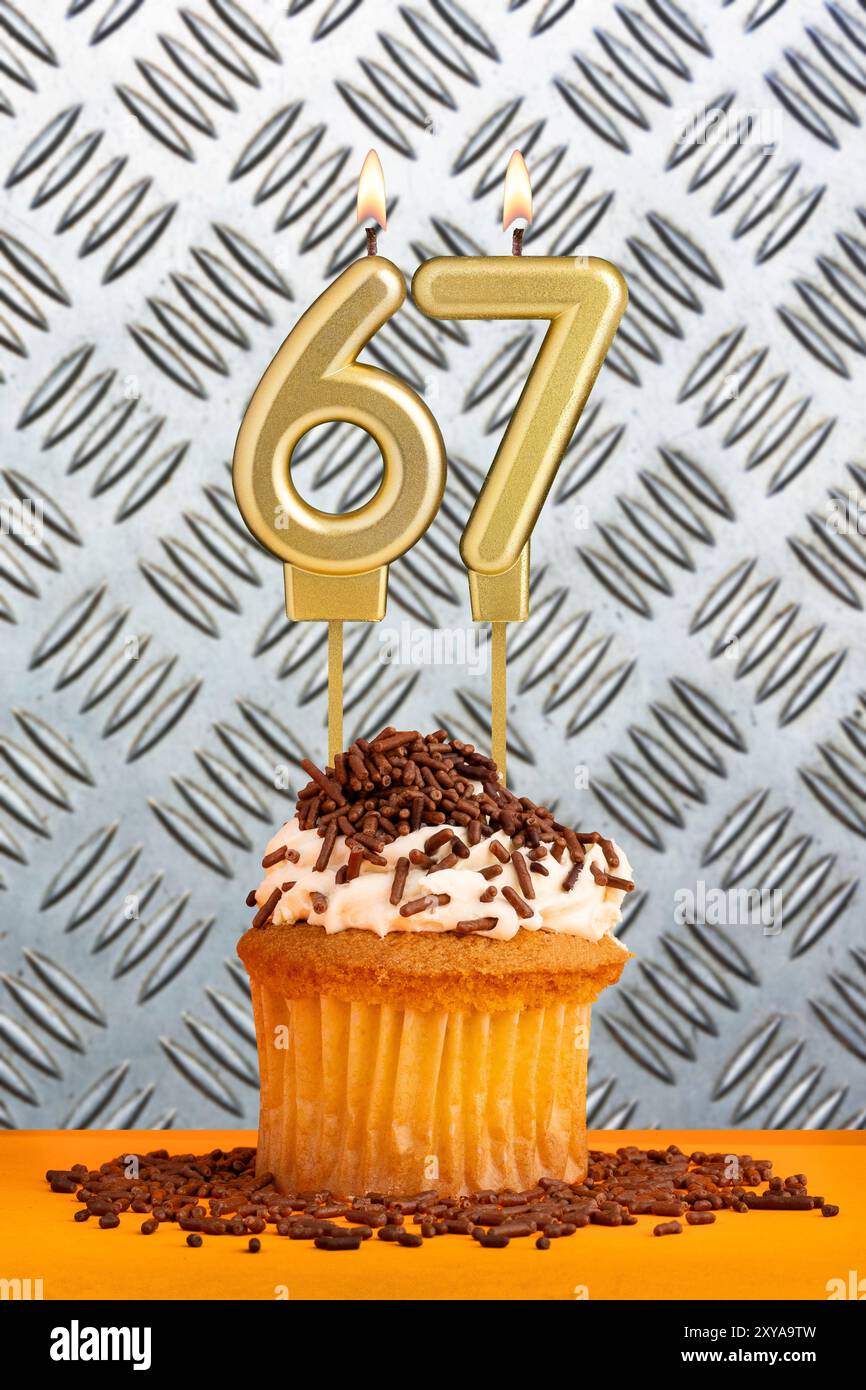Chocolate cupcake with candle number 67 - Birthday on industrial ...