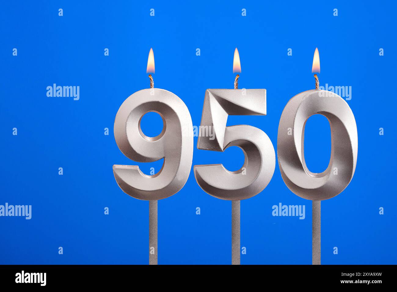 Birthday number 950 - Candle lit on blue background Stock Photo - Alamy