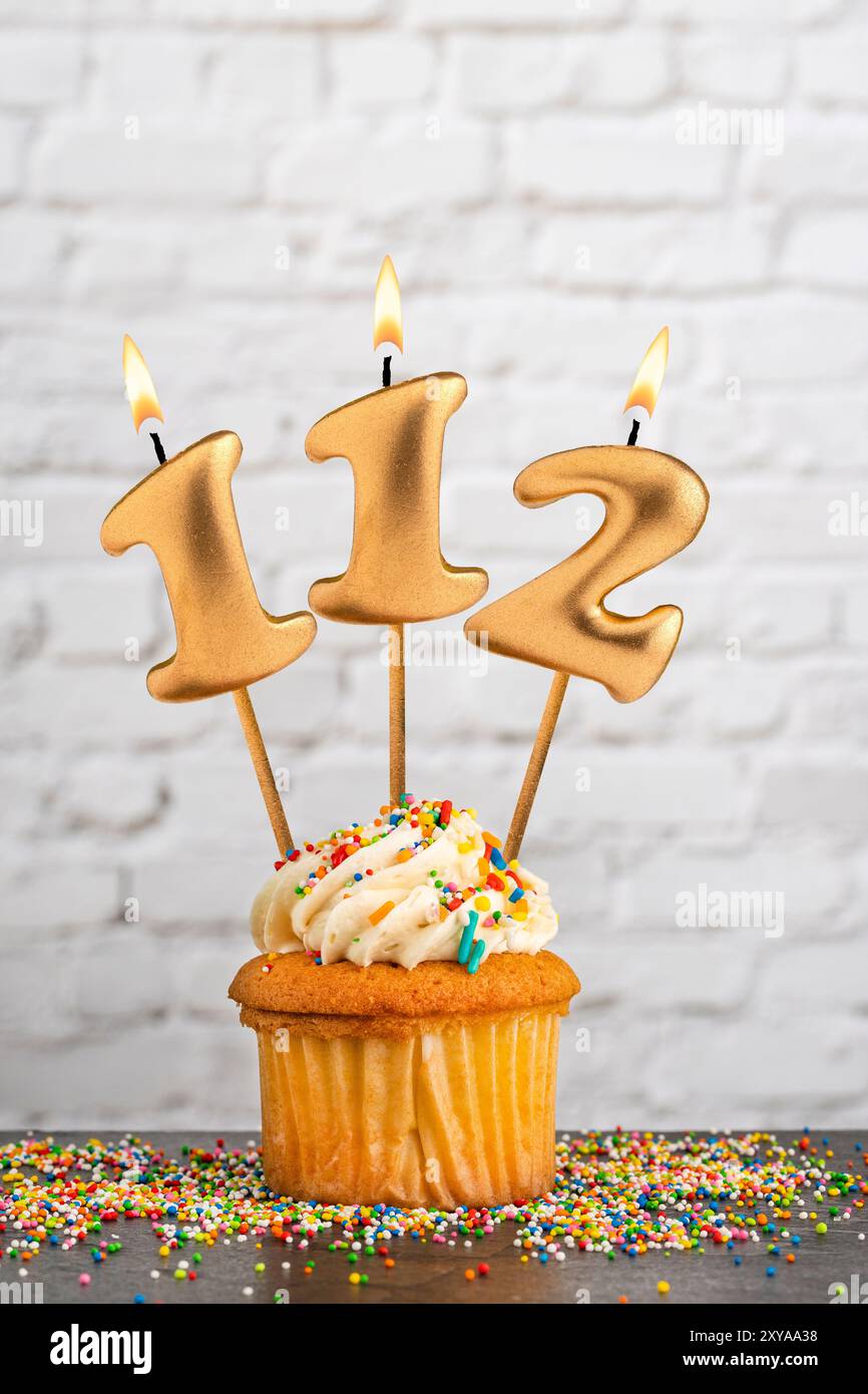 Cupcake with number 112 birthday candle - White block wall background ...