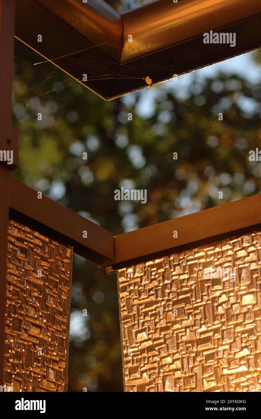 A textured glass surface catches the soft glow of sunset, featuring a ...