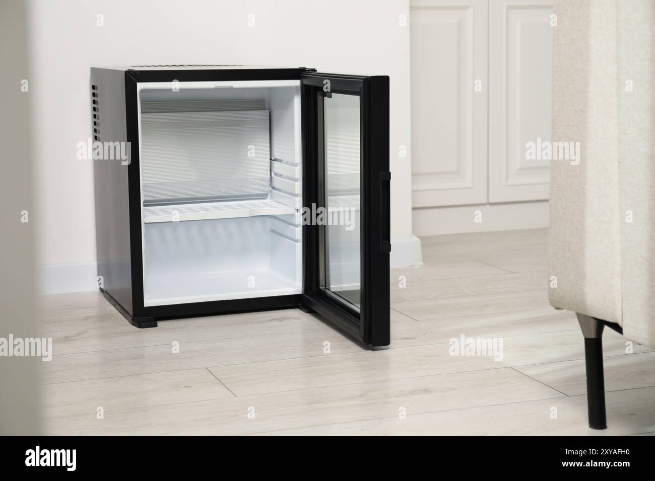 Empty modern mini refrigerator on floor indoors Stock Photo - Alamy