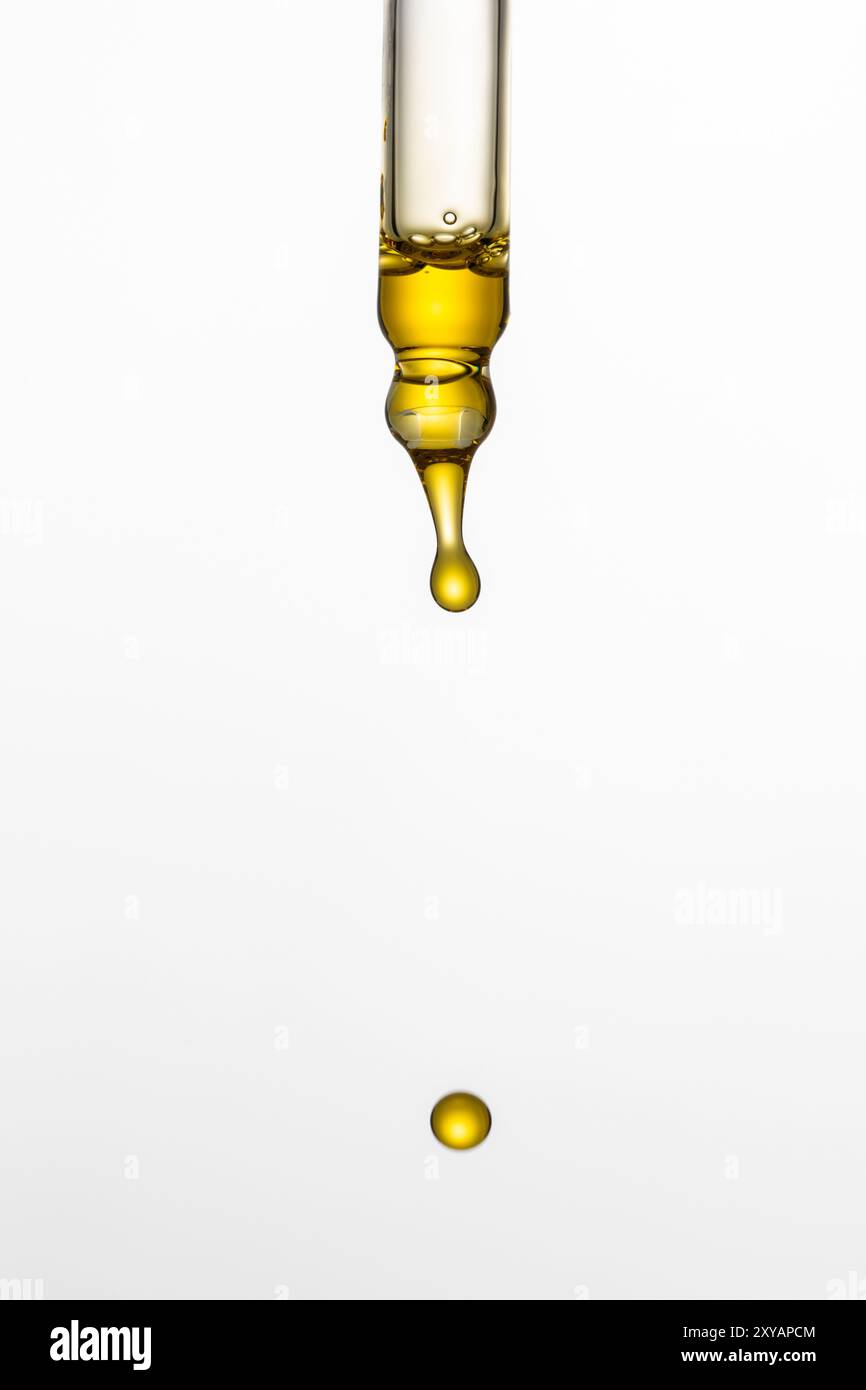 Dripping cosmetic serum from pipette on white background. Face serum ...
