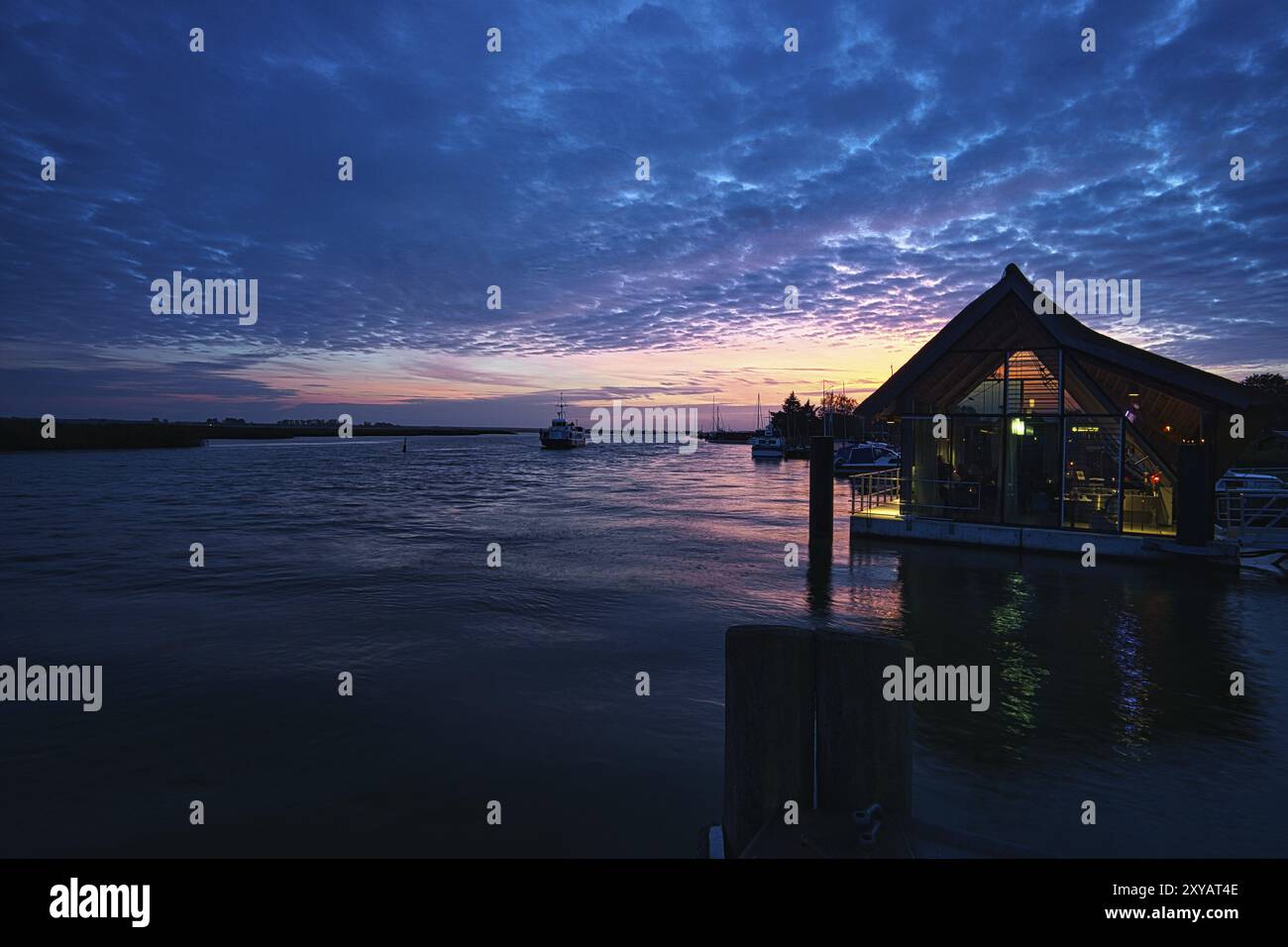From the harbor in zingst the bodden view with burning sky with house ...