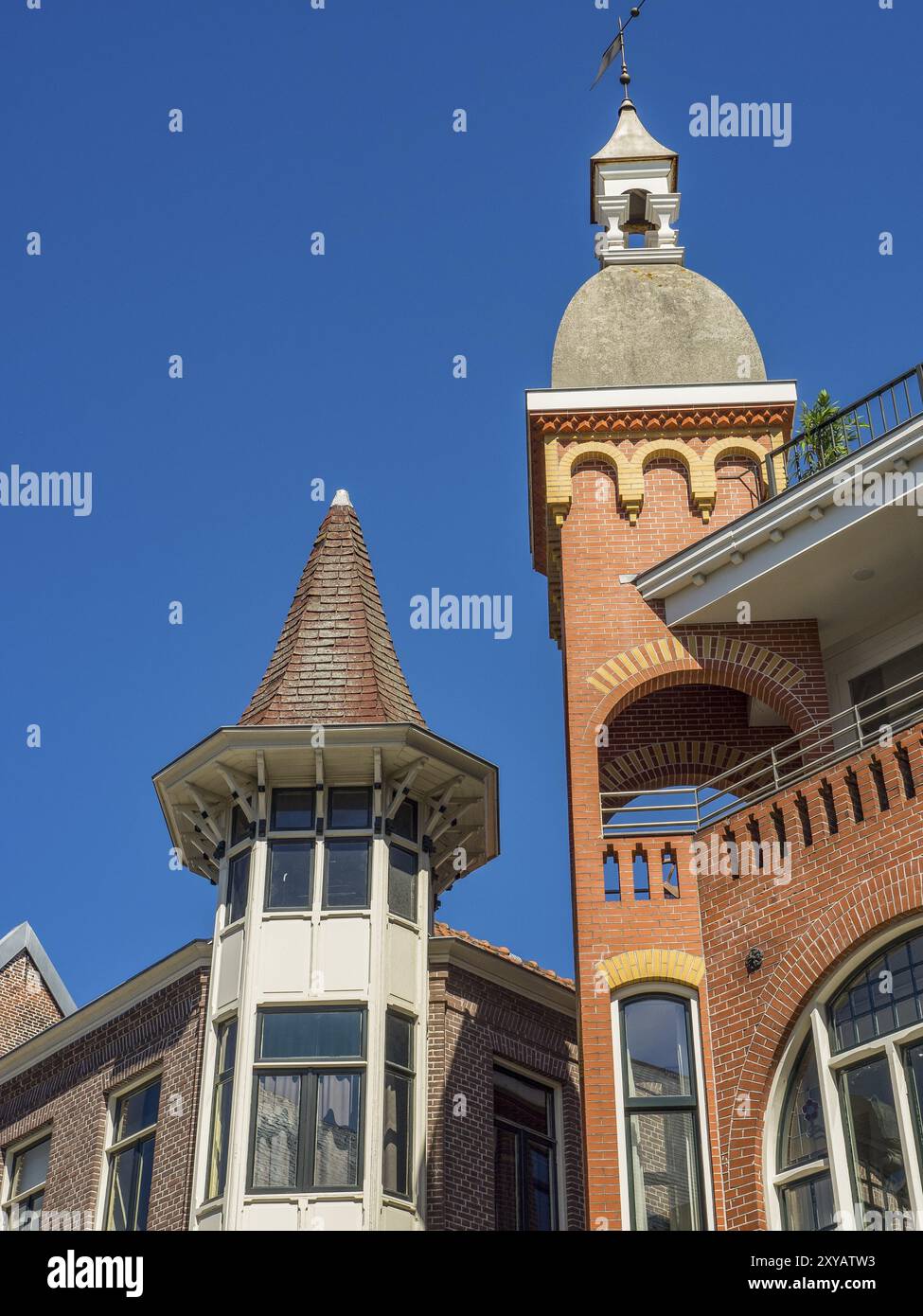 Two differently shaped towers of a brick building in front of a clear ...