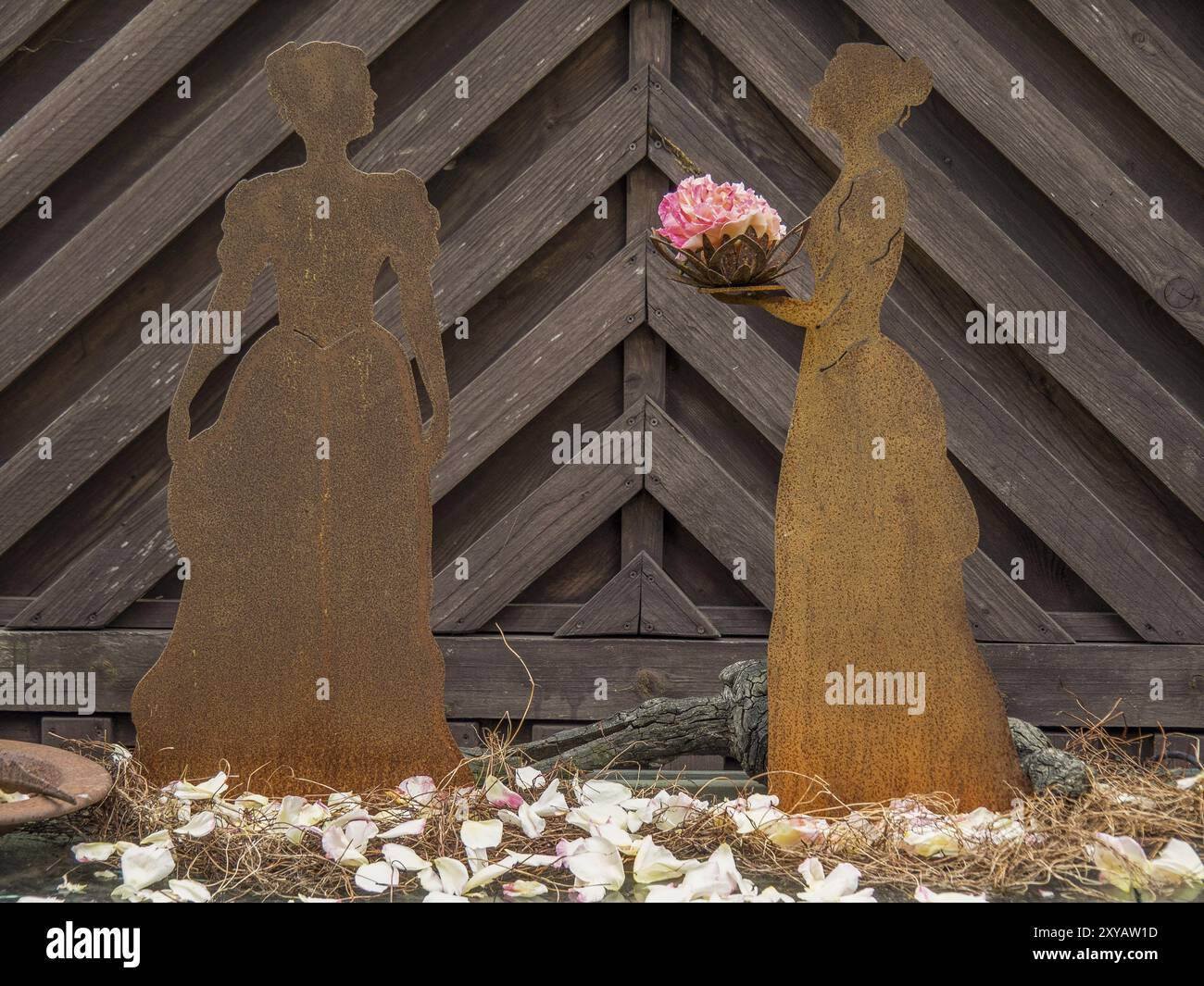 Two metal silhouettes with a rose blossom, many petals on the floor ...
