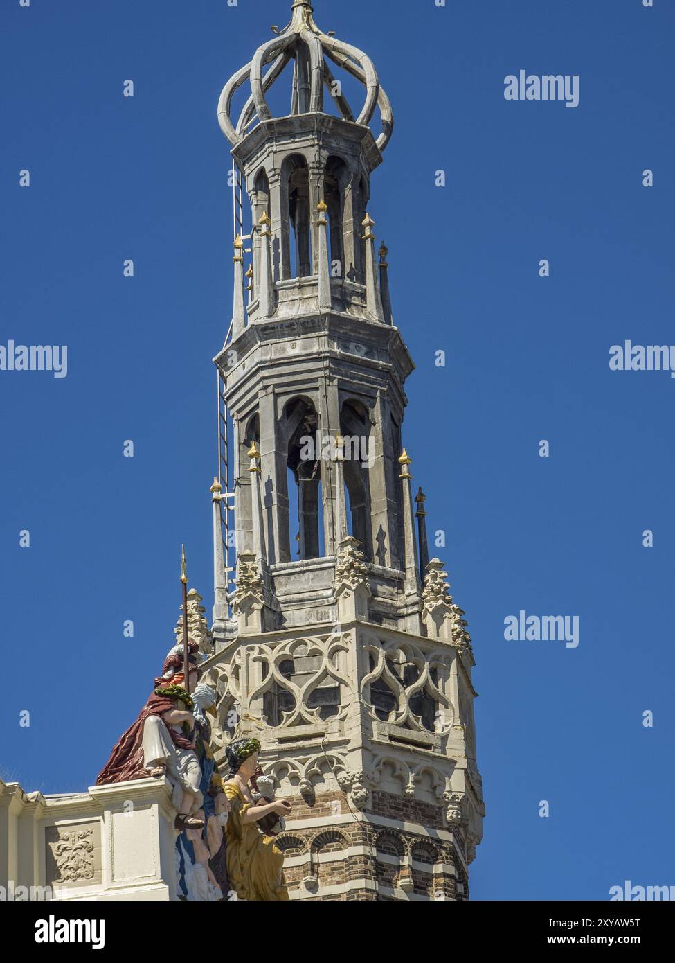 A gothic bell tower with detailed decorations against a clear blue sky ...